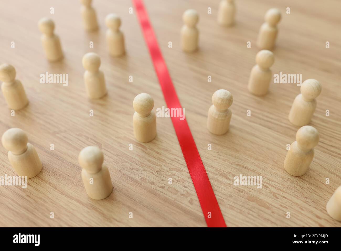 Red ribbon separates groups of wooden figurines on table Stock Photo ...