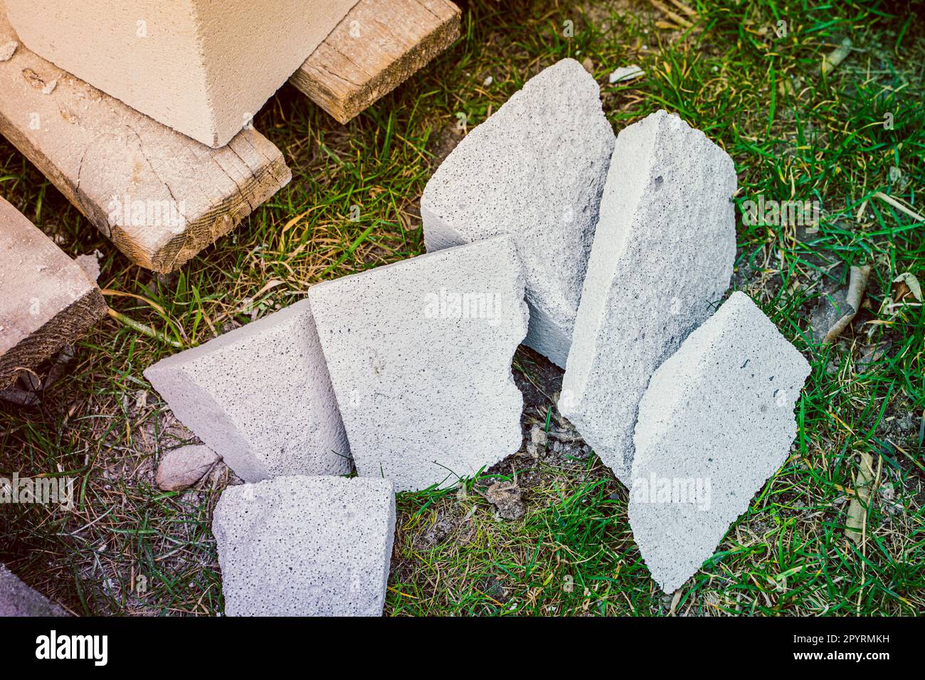 Shards after cutting aerated concrete lie on the grass. Chipped pieces ...