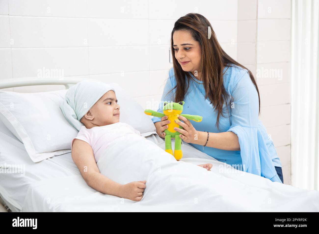 Indian woman with toy visiting her little daughter or cancer patient ...