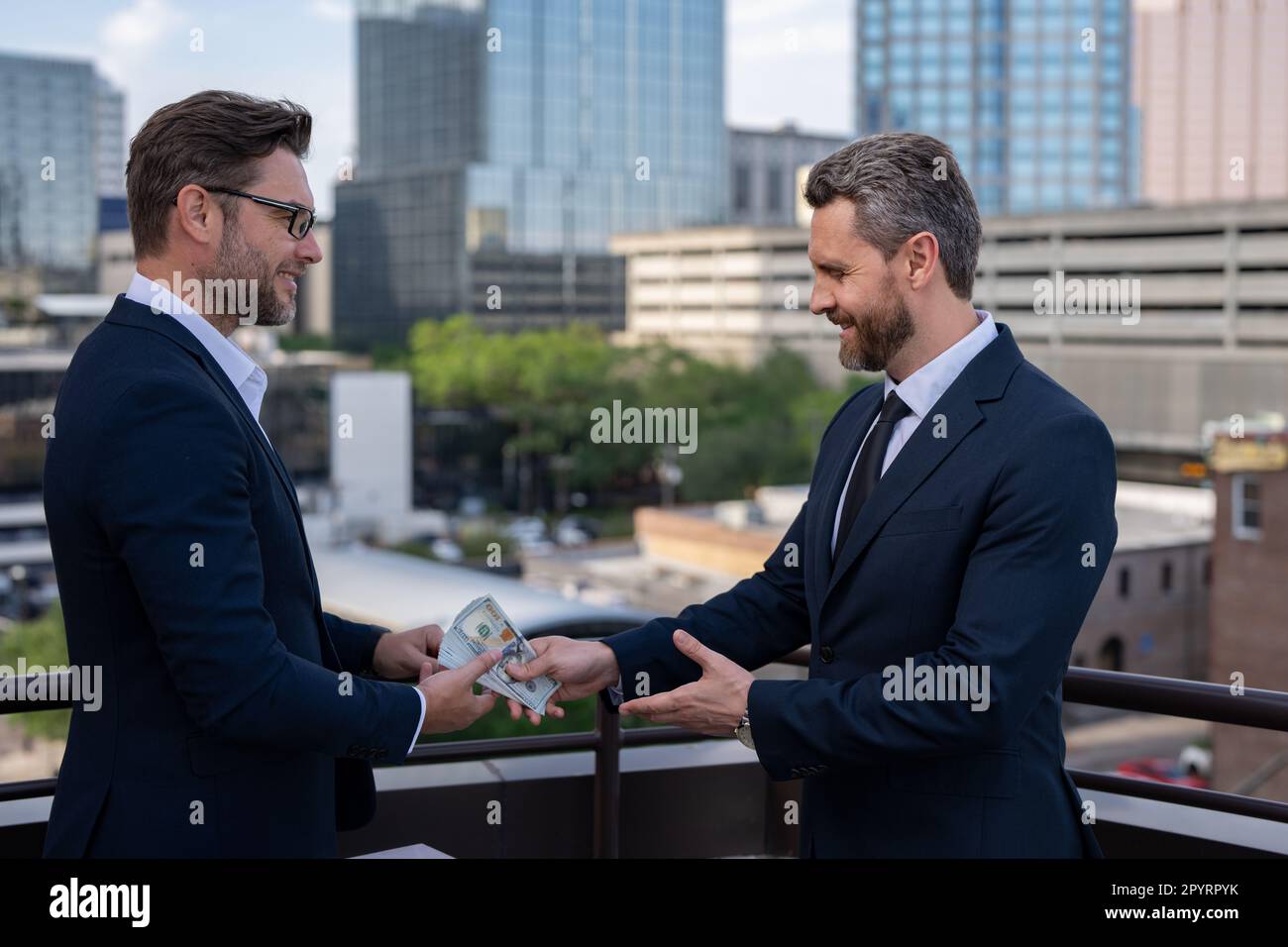 Businessman giving money to his partner while making contract ...