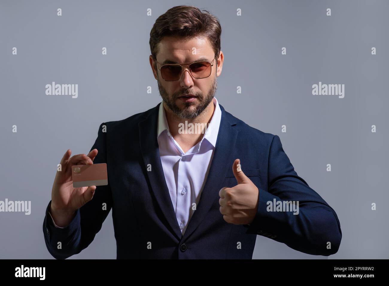 Portrait of serious arrogant proud business man showing plastic credit ...