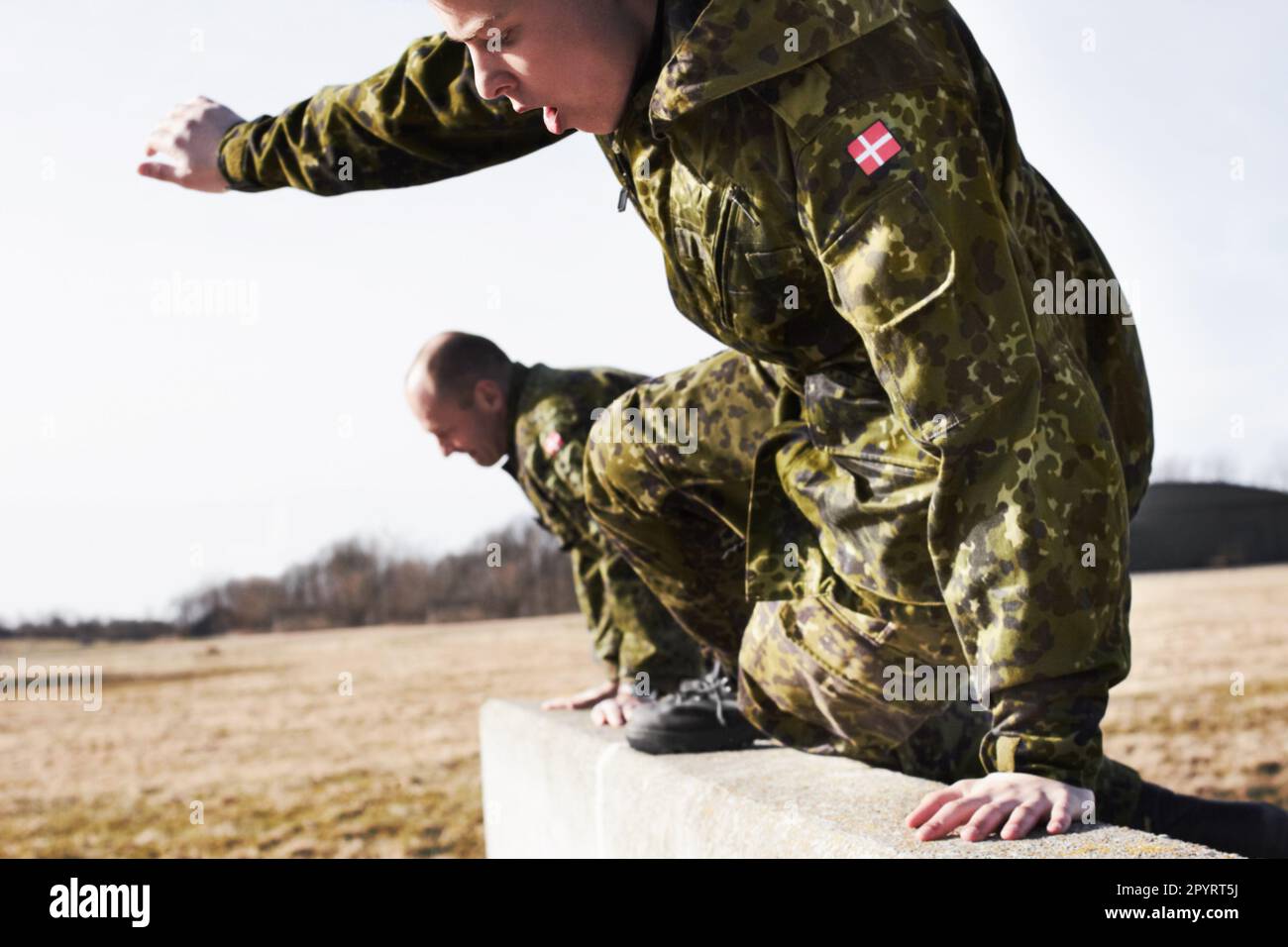 Soldier in training, military men and jump over a wall in obstacle ...