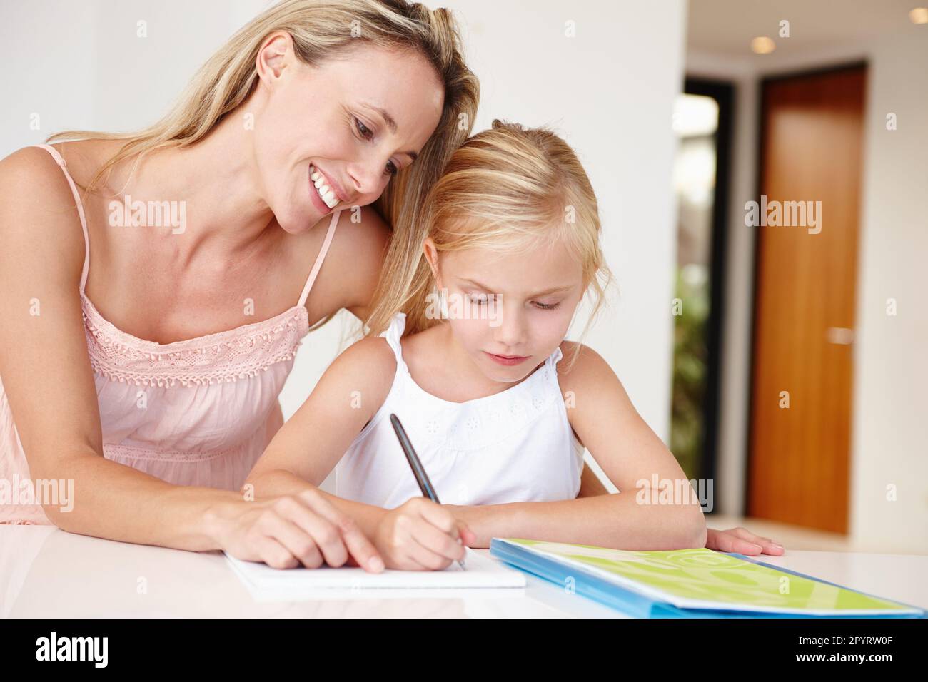Involved in her daughters education. a loving mother helping her daughter with her homework ...