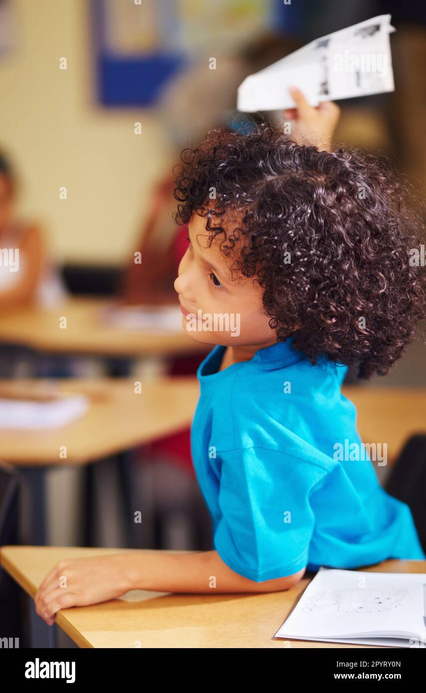 School, education and paper airplane with a student boy playing in ...