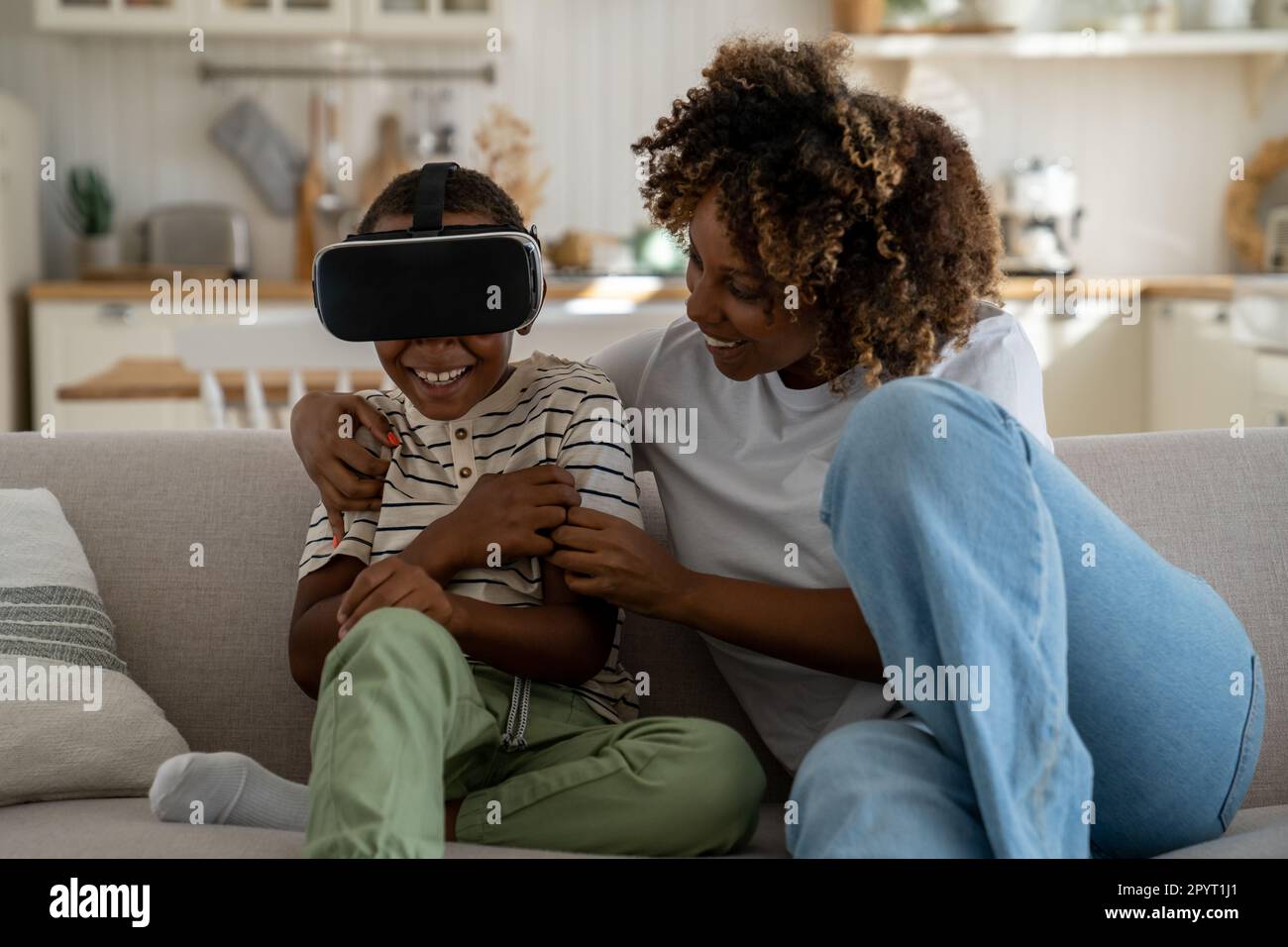 Happy joyful African American family mother and son using VR headset ...