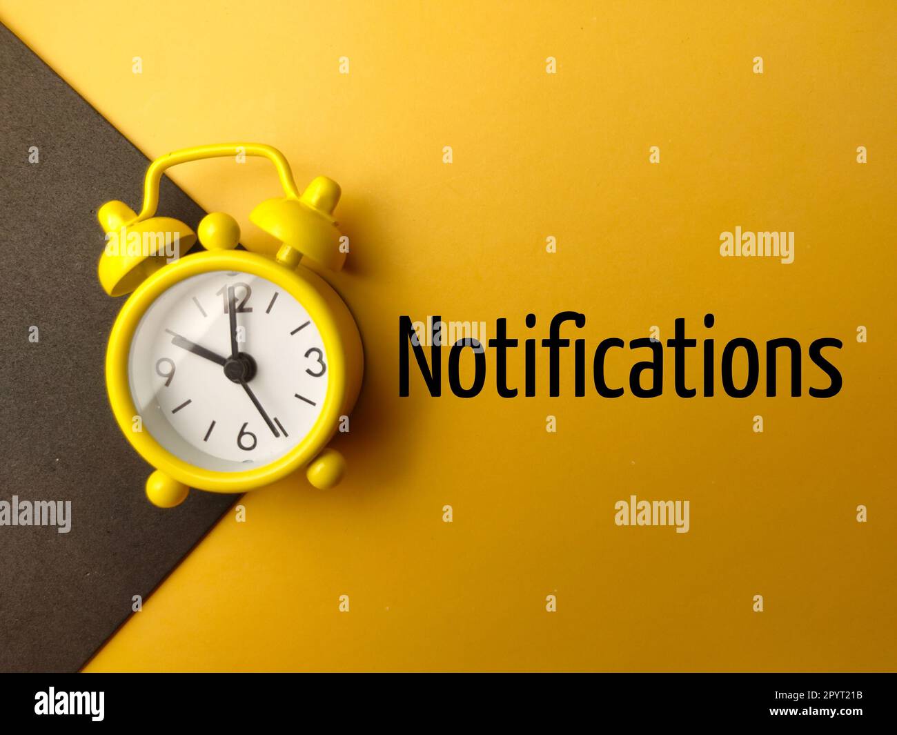 Top view alarm clock with the word Notification on yellow background ...