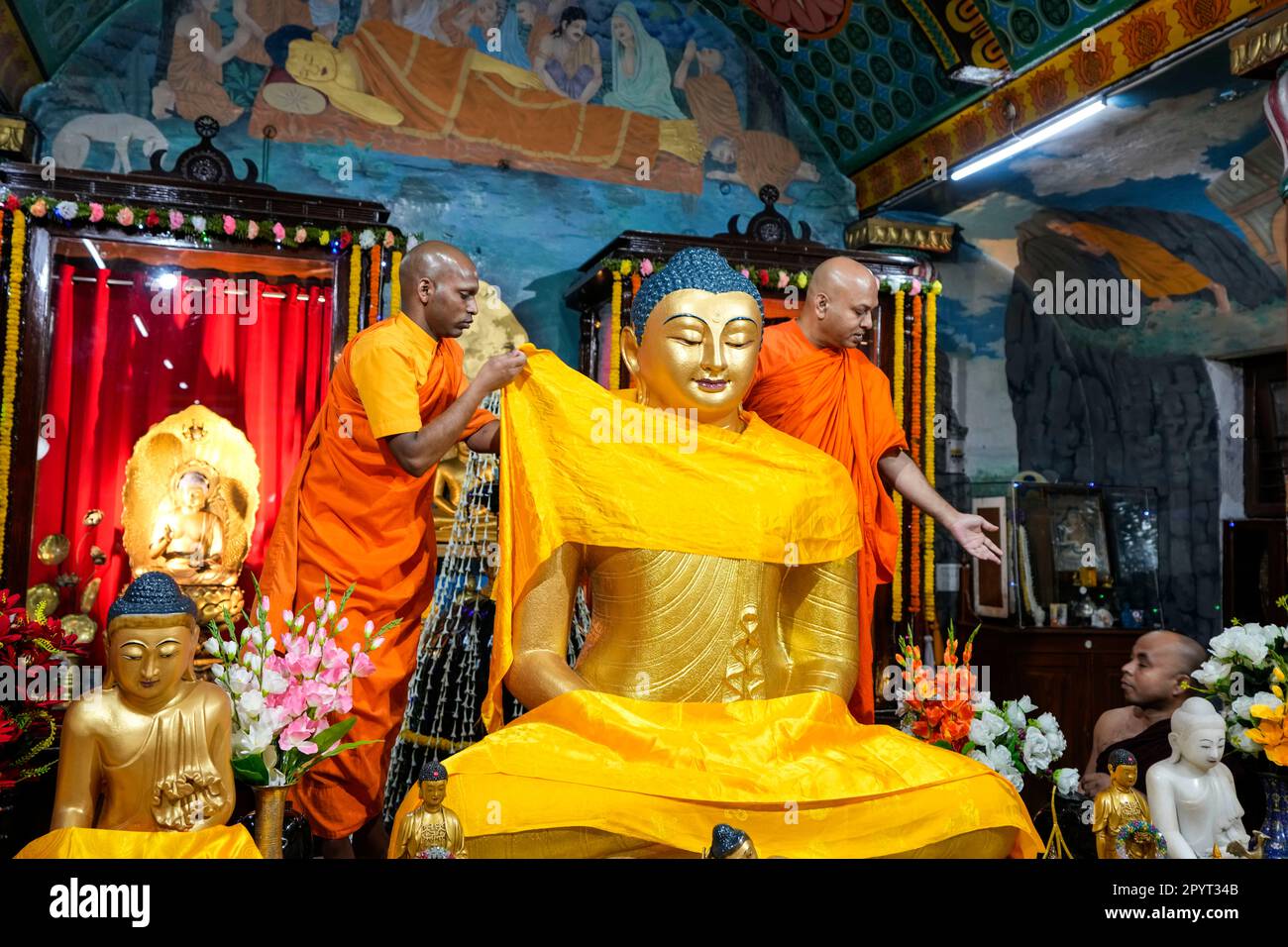 Buddhist monks decorate a statue of Buddha during Buddha Purnima ...