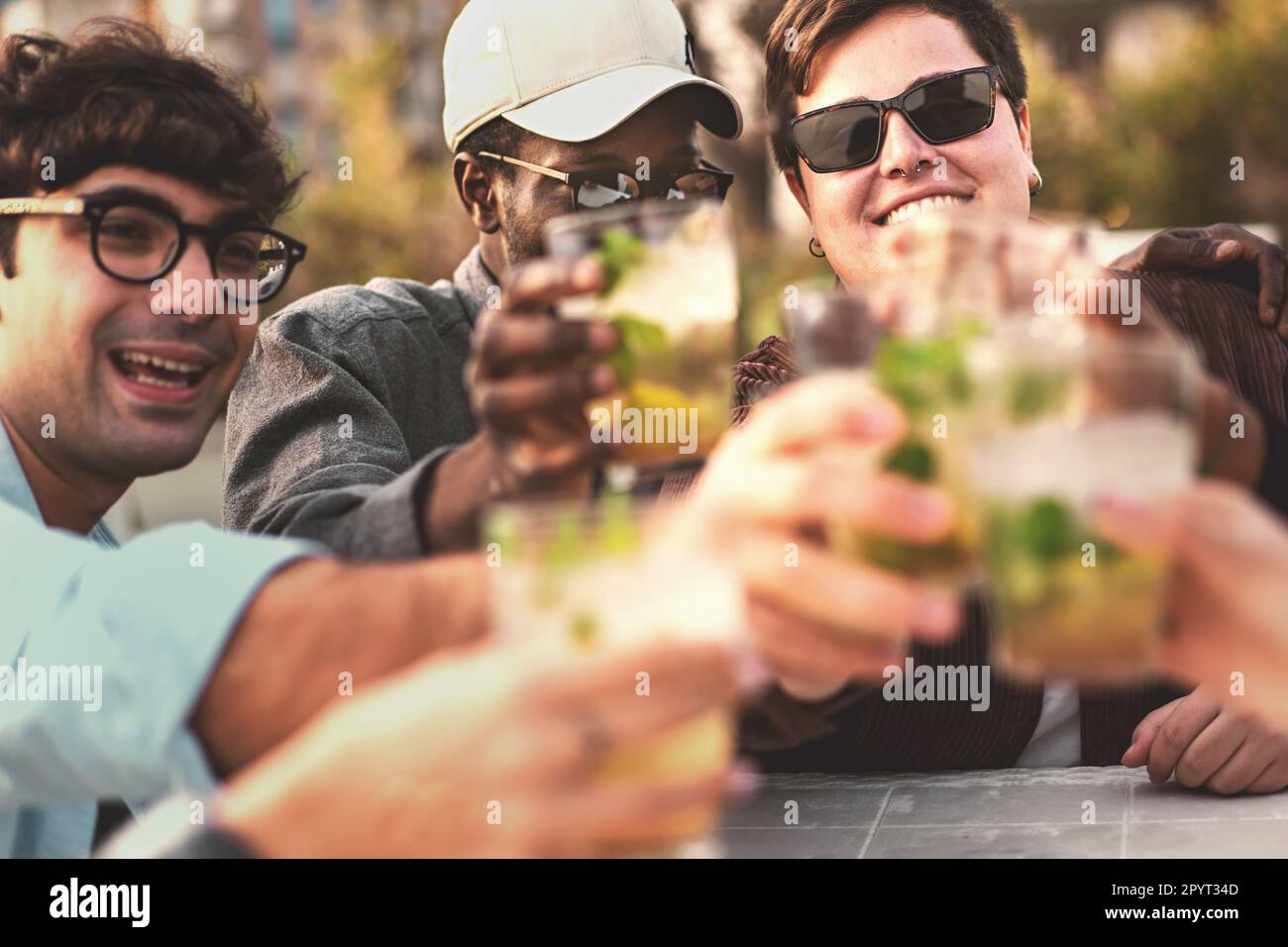 A Non Binary Individual Wearing Sunglasses And A Nose Piercing Enjoys Fresh Cocktails With Their