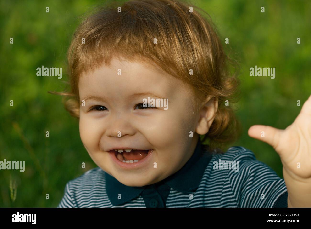 Portrait of cute excited boy having fun in garden. Baby face close up ...