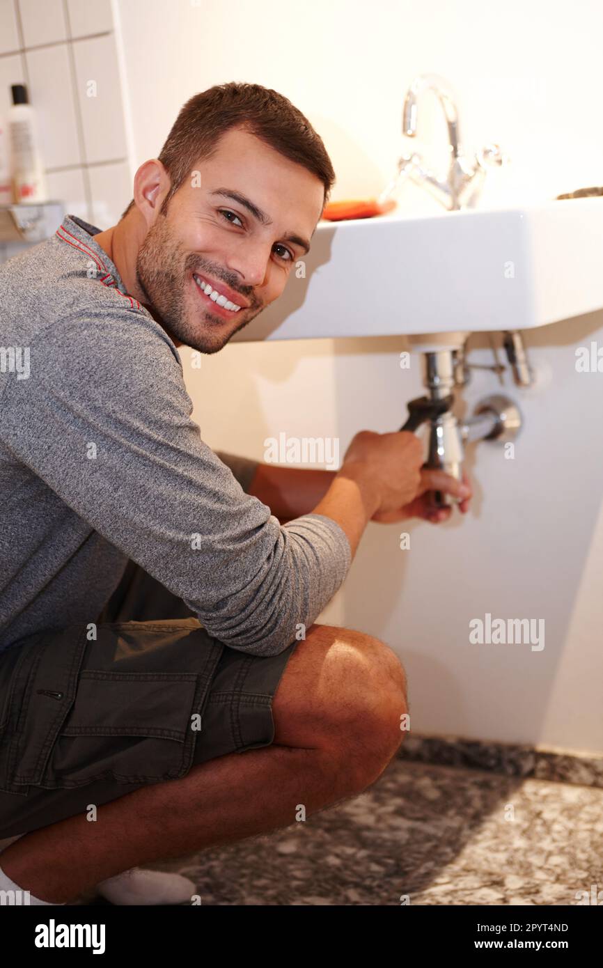 Hell patch up those pipes. Portrait of an attractive young man fixing a ...