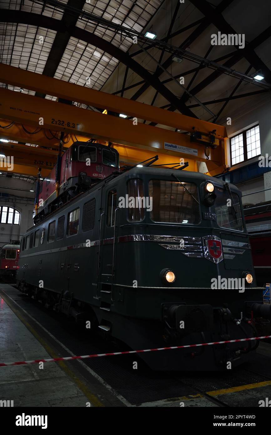 A vertical of a passenger train at the station with power lines in the ...