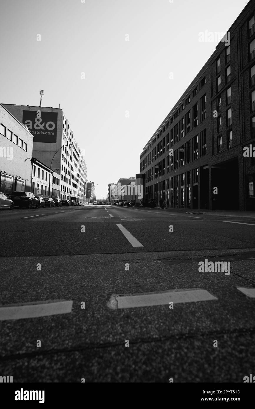 A vertical of modern building in a busy street ith shops and ...