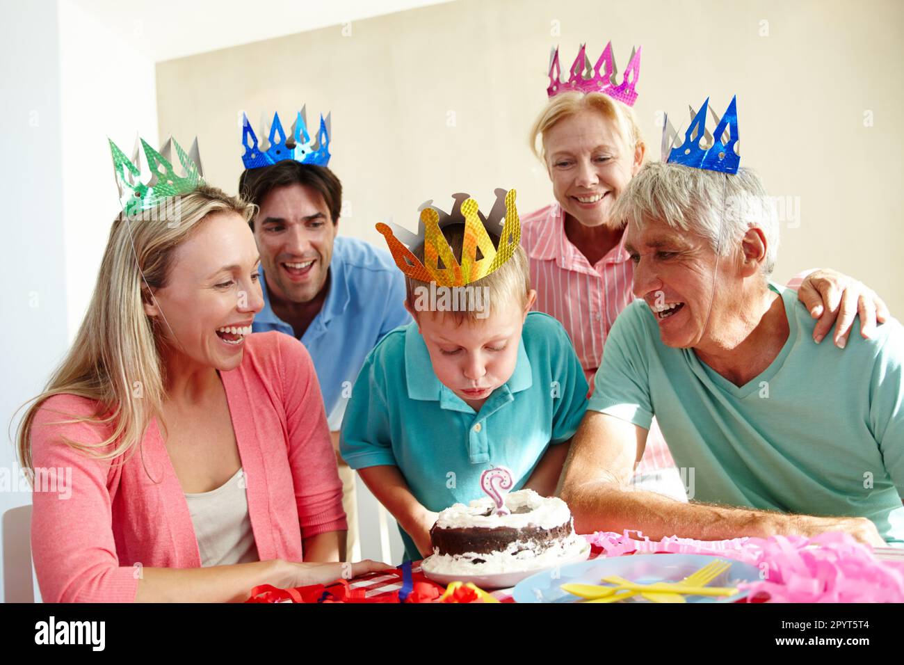 Make a wish. a little boy celebrating his birthday with all his family ...