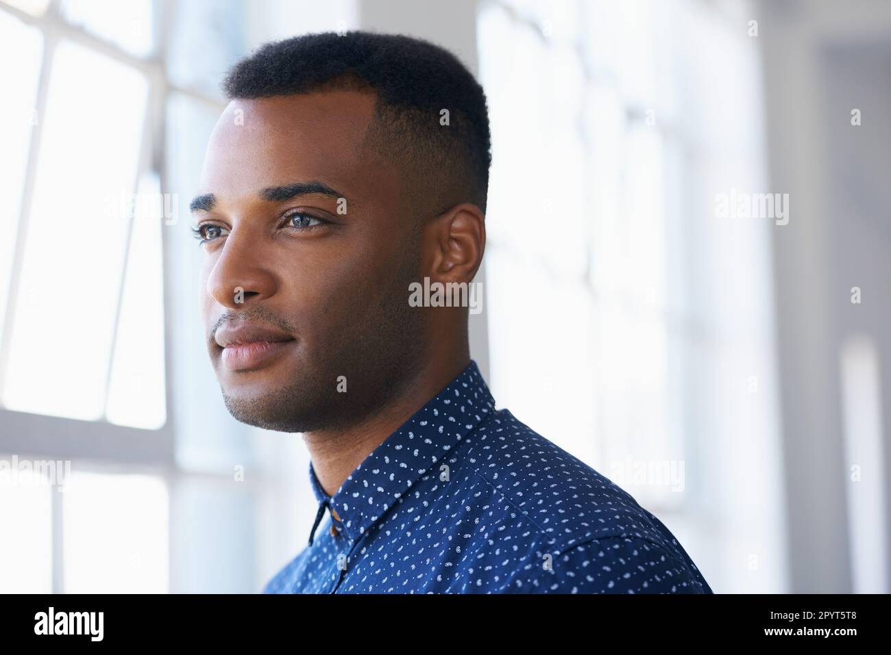Contemplating his future. Profile of a young ethnic man looking ...