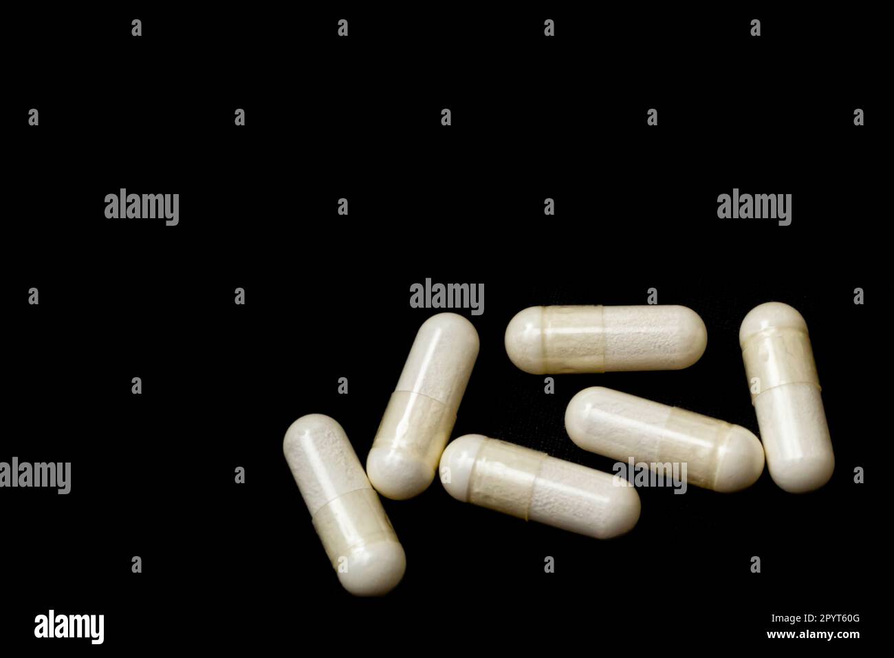 White capsules, pills on a black background with place for text ...