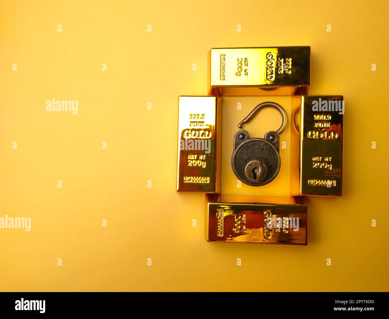 Vintage padlock with gold bar on a yellow background Stock Photo - Alamy