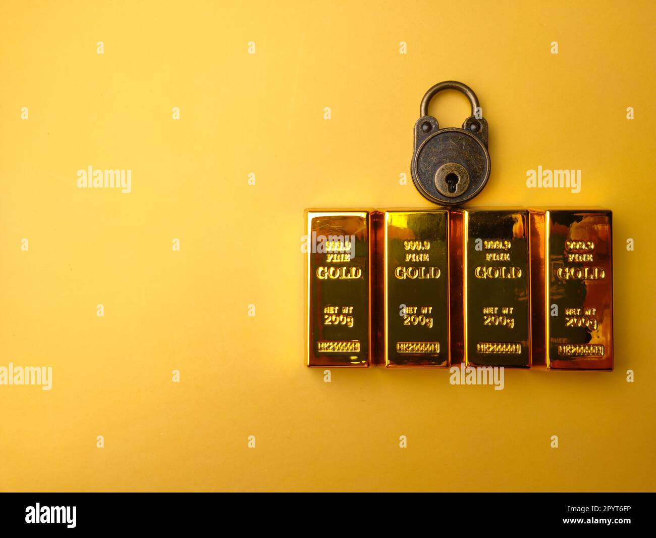 Vintage padlock with gold bar on a yellow background Stock Photo - Alamy