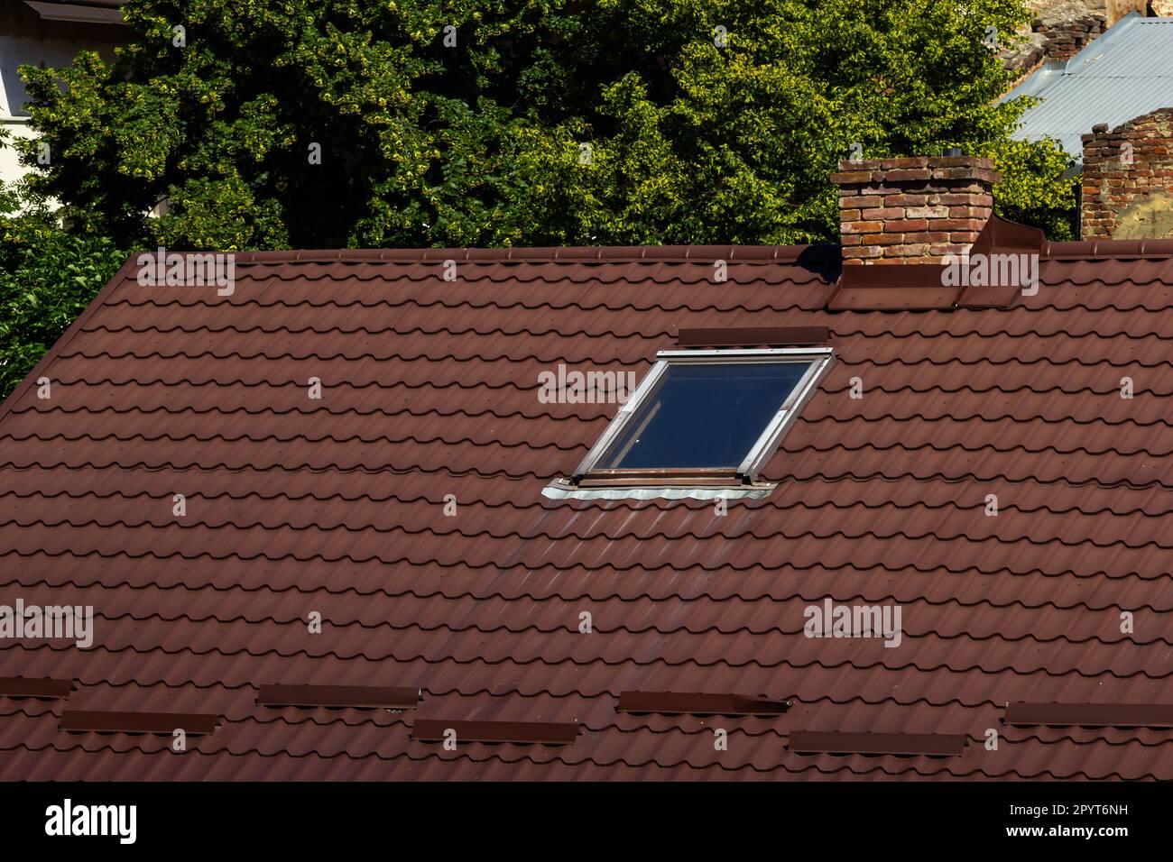 Roof of a new home. Ceramic chimney, metal roof tiles, gutters, roof ...