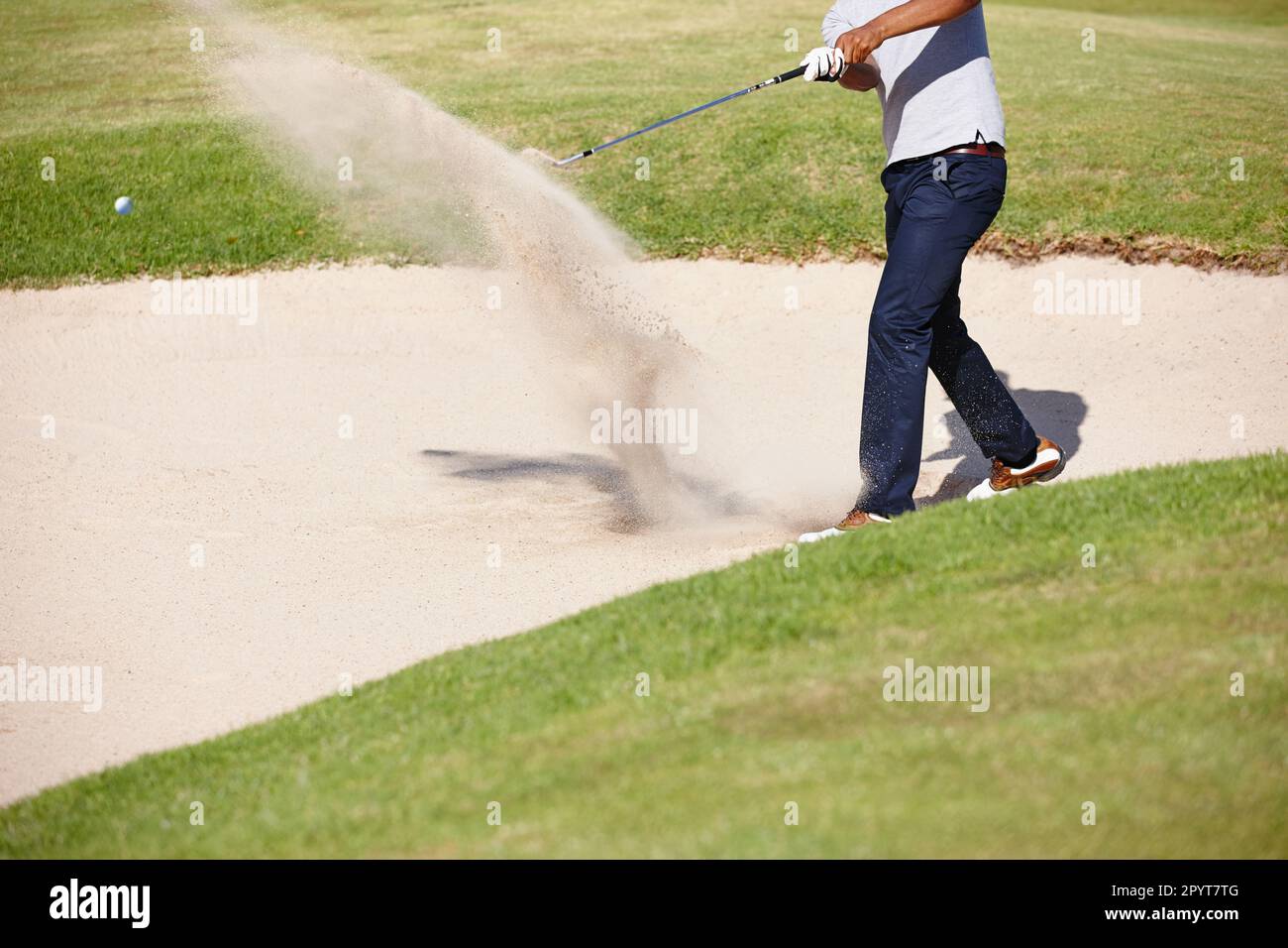 Sport holding standing golf club hitting sand trap hi-res stock ...
