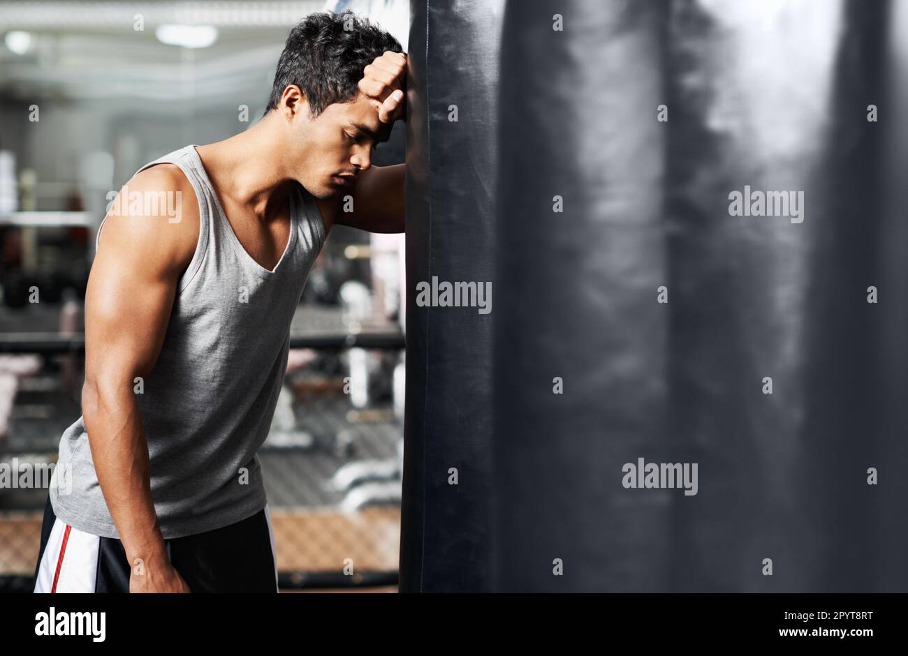 Life always throws him a punch. A muscular young man leaning against a ...