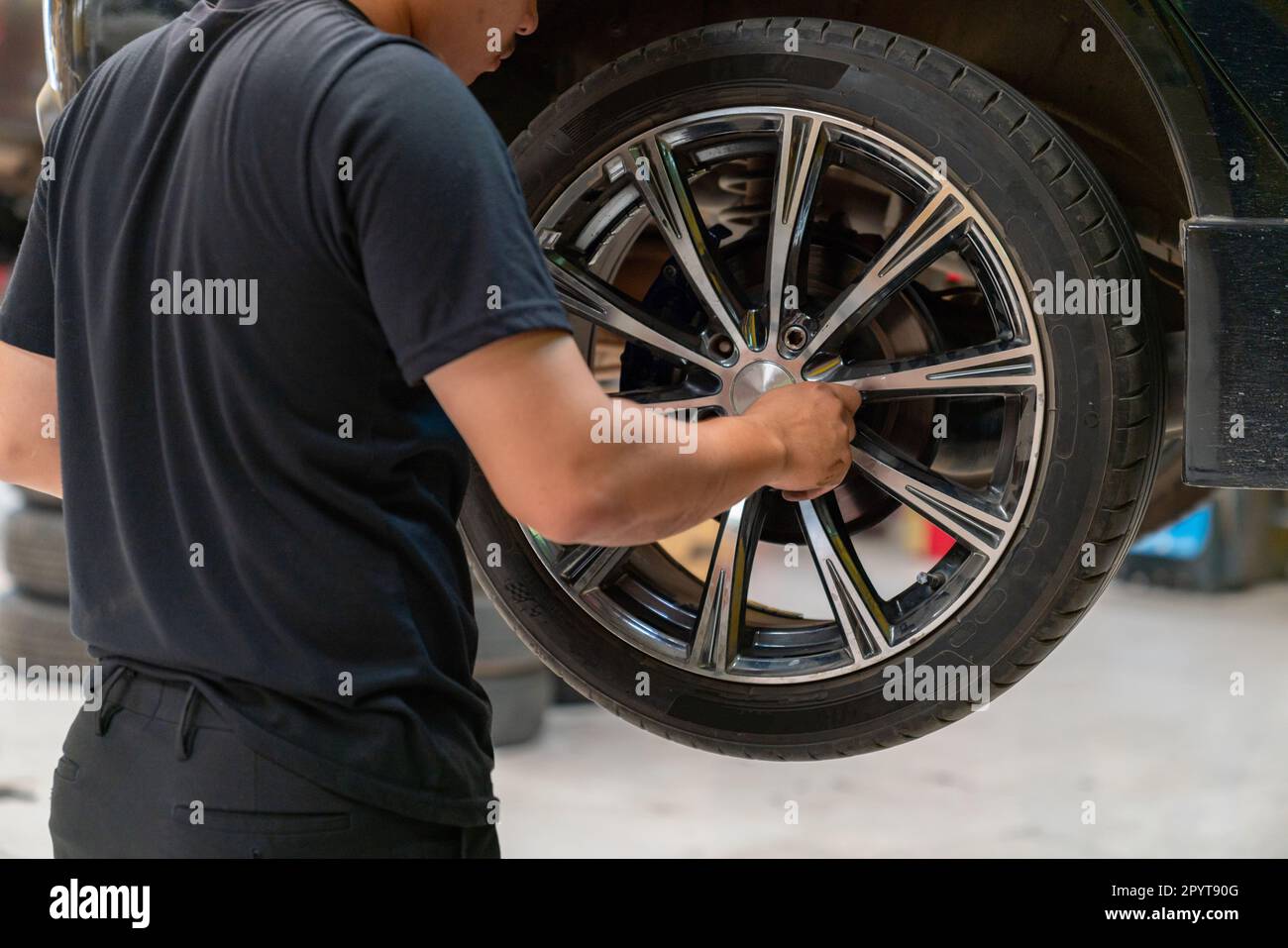 Technician install wheels in service shops Stock Photo - Alamy