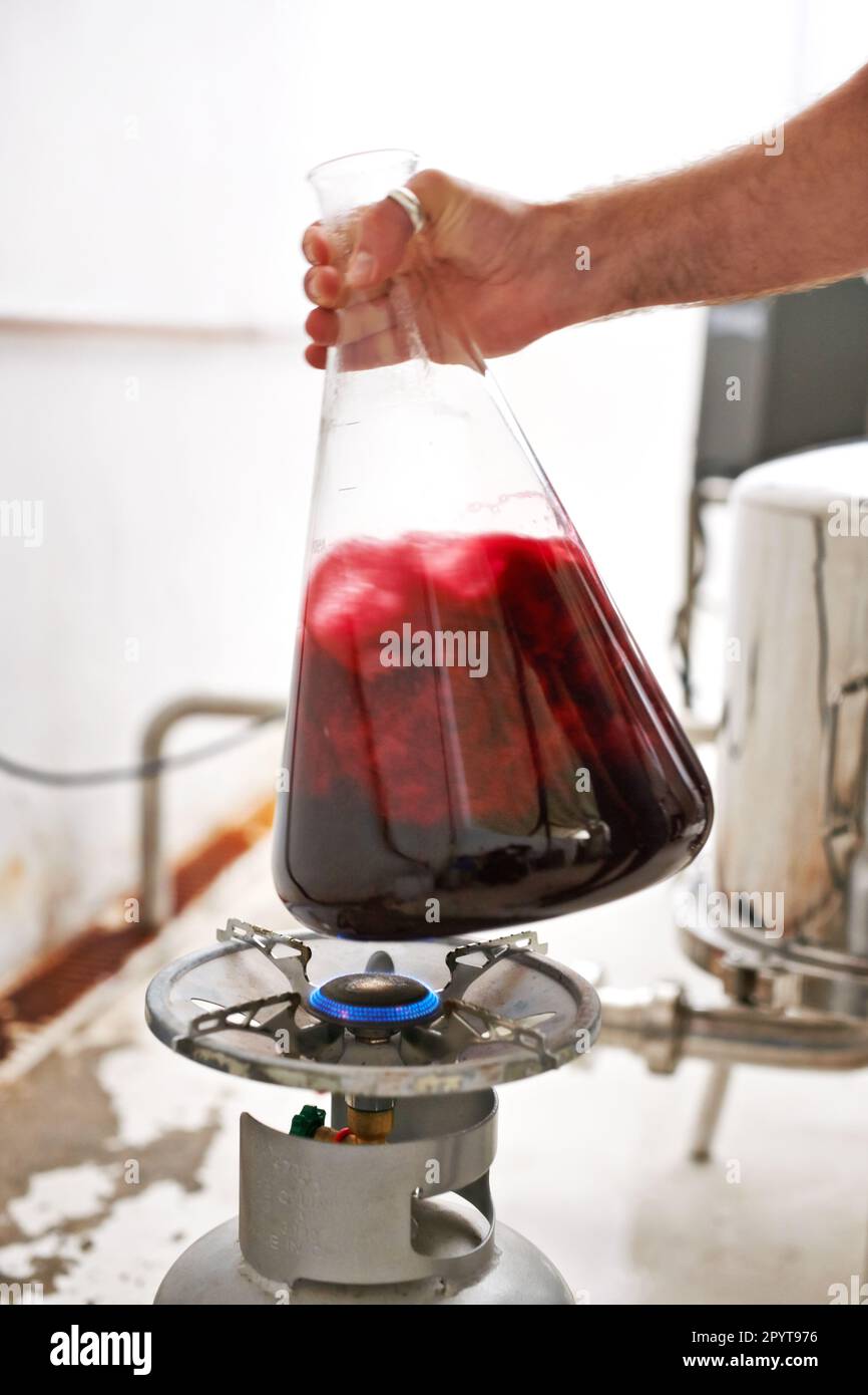 Weird science. a beaker of red liquid over a bunson burner Stock Photo ...