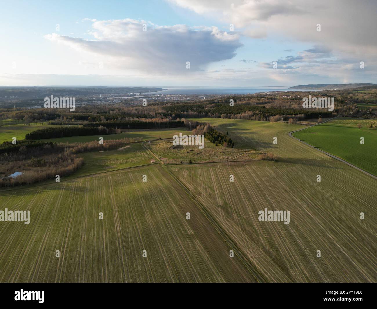 An aerial shot of an agricultural field with a cloud-filled sky ...