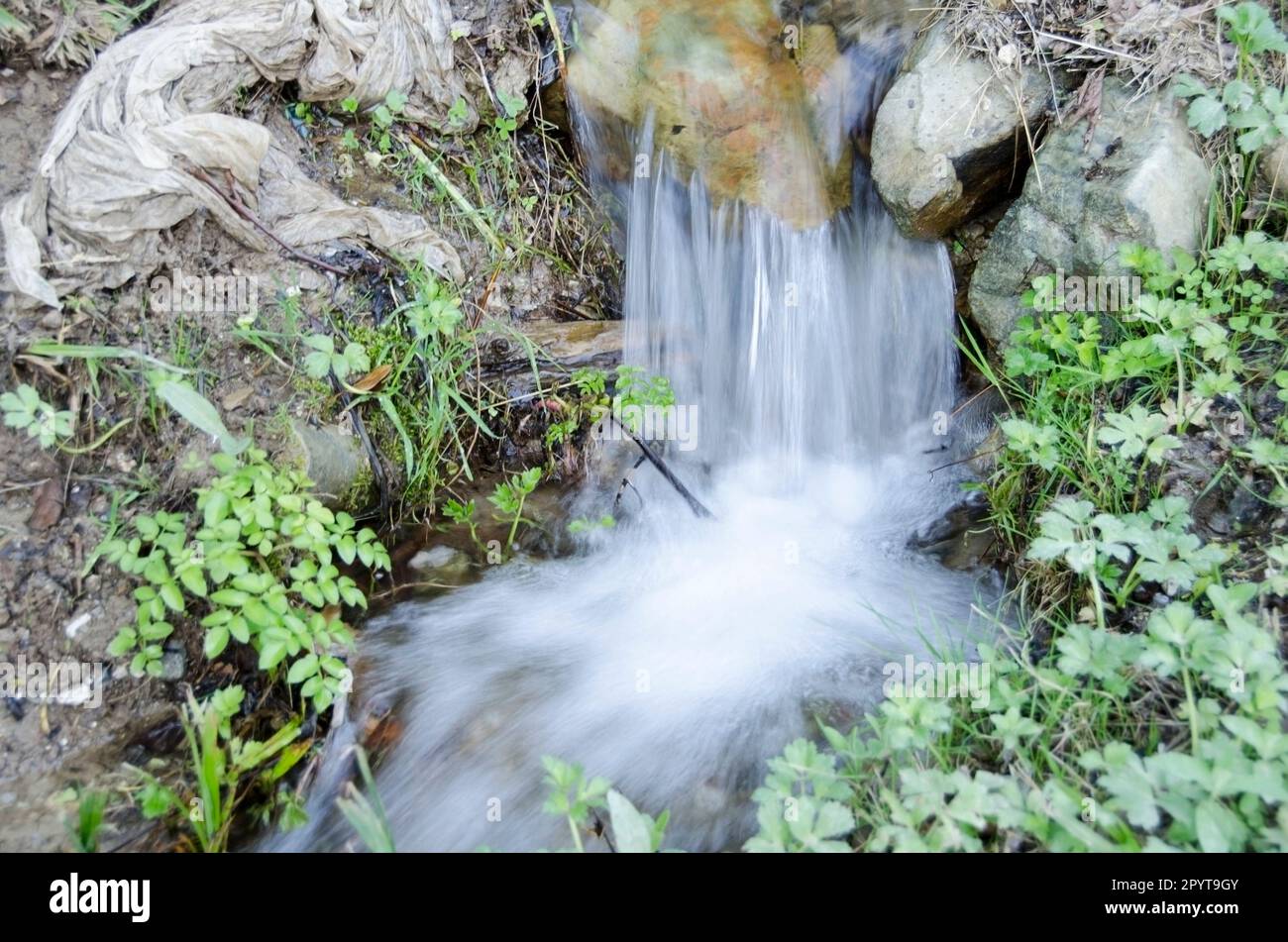 Beautiful Small waterfall in the forest polluted with plastic bags and ...