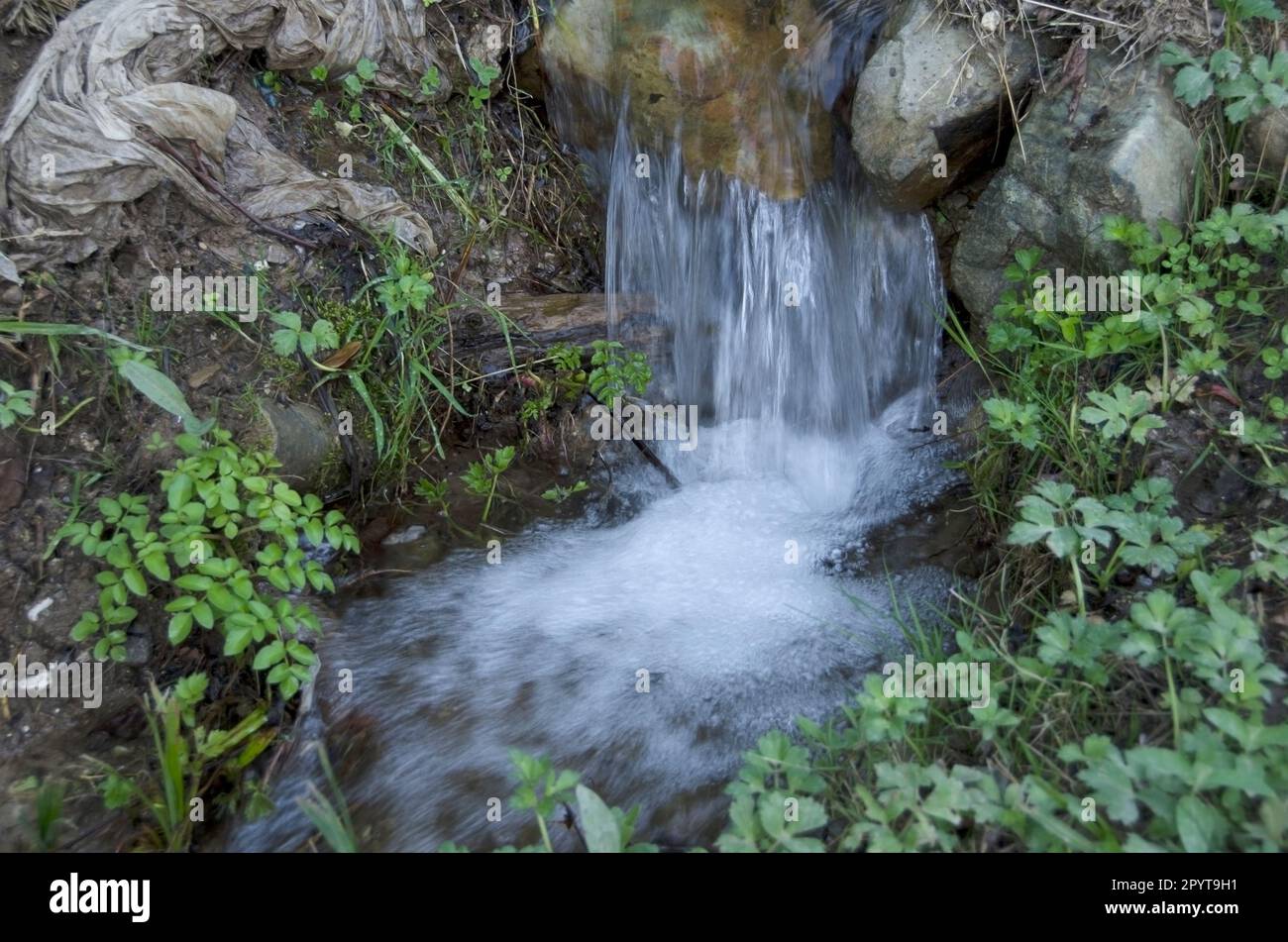 Beautiful Small waterfall in the forest polluted with plastic bags and ...