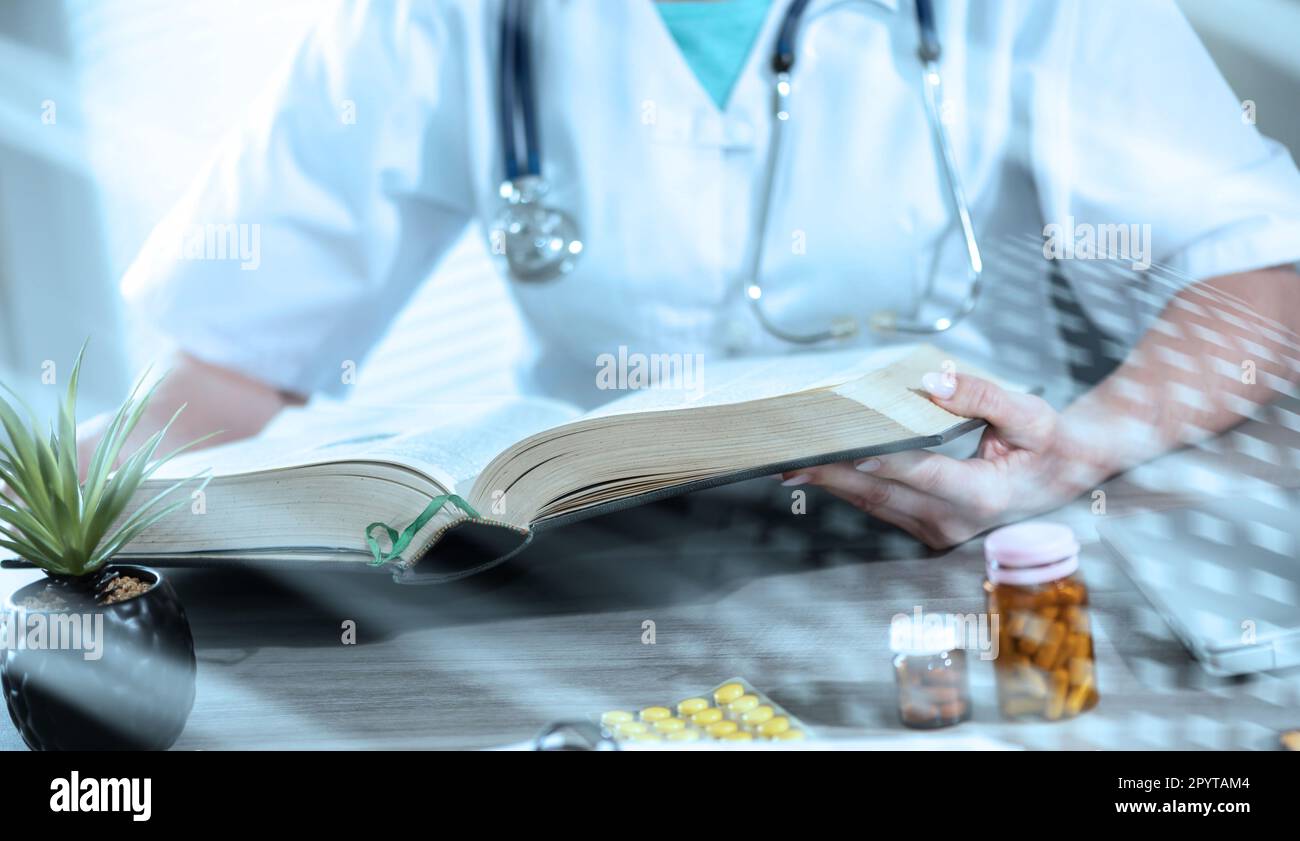Female doctor reading a textbook in medical office; light effect Stock ...