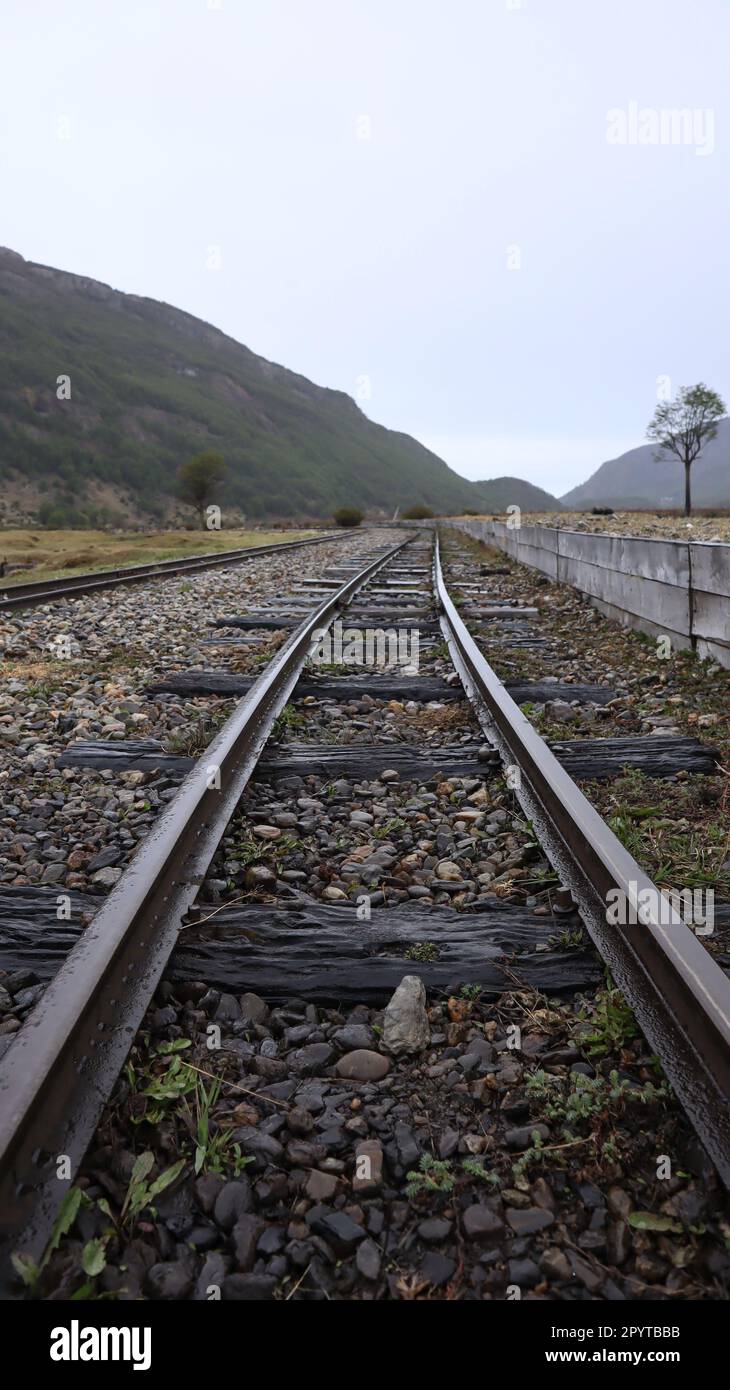 An abandoned train track among a scenic backdrop of mountains and rocks ...