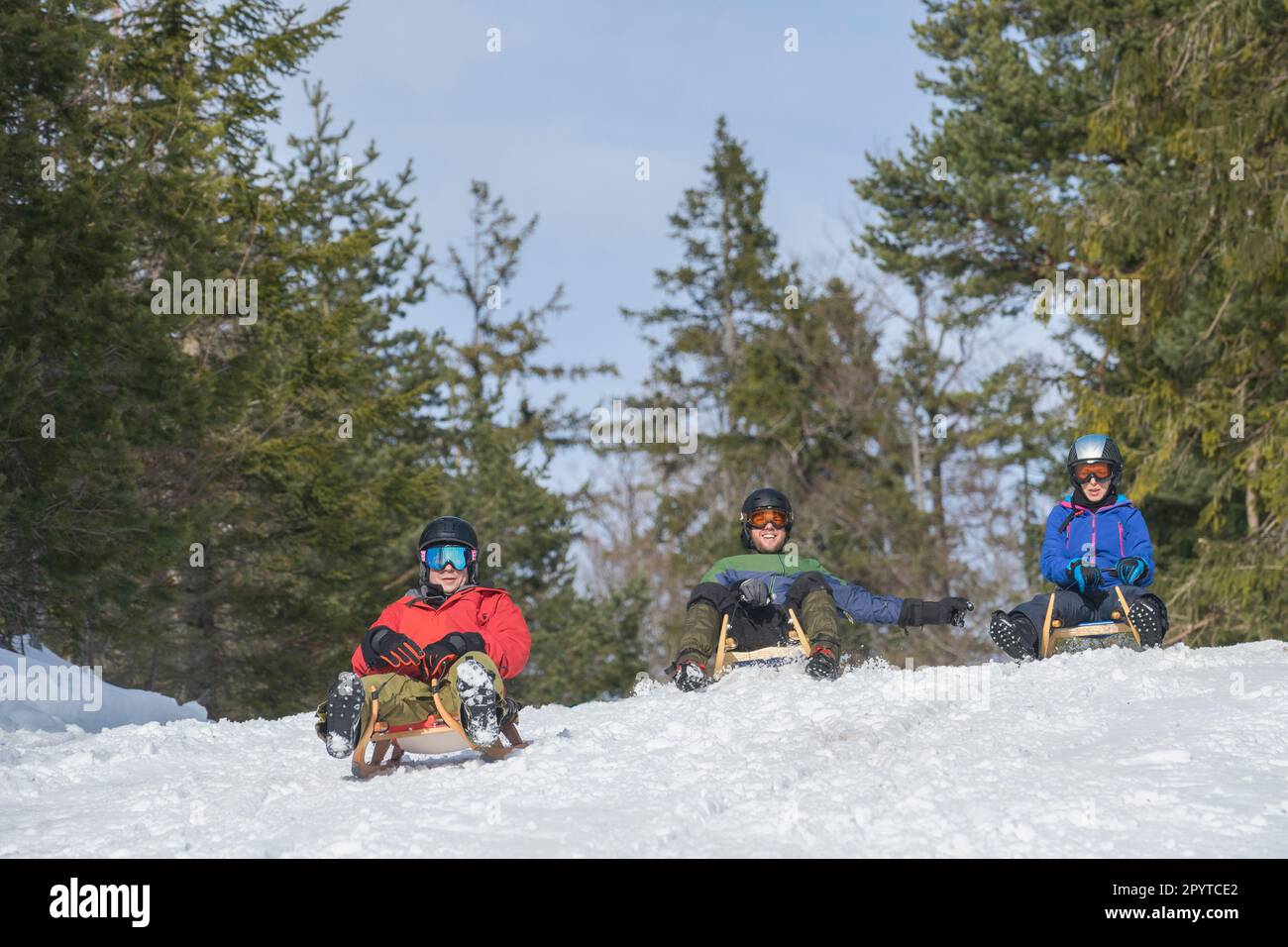 Friends sledding on winter landscape Stock Photo - Alamy