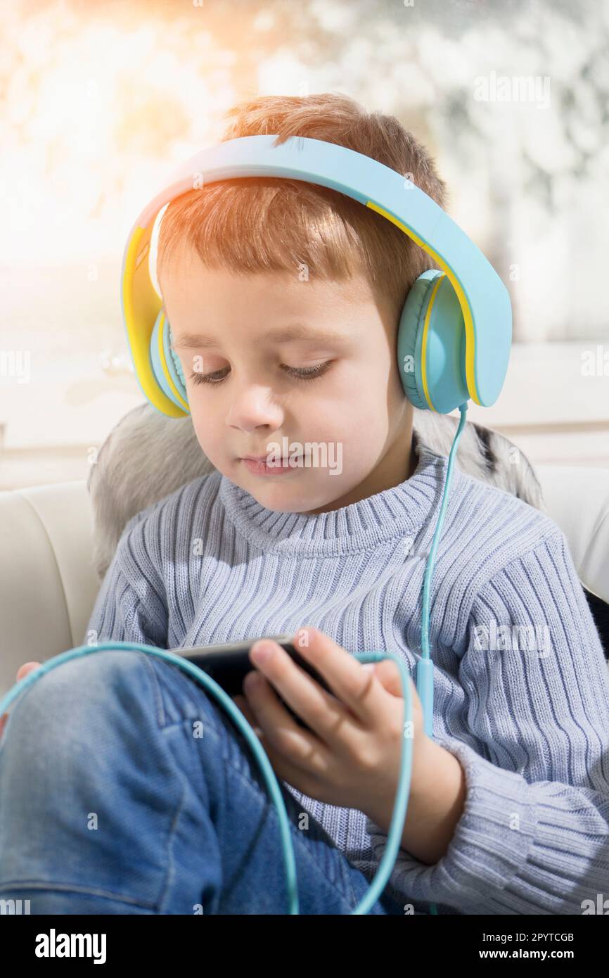 Boy listening music using digital tablet and headphones Stock Photo - Alamy