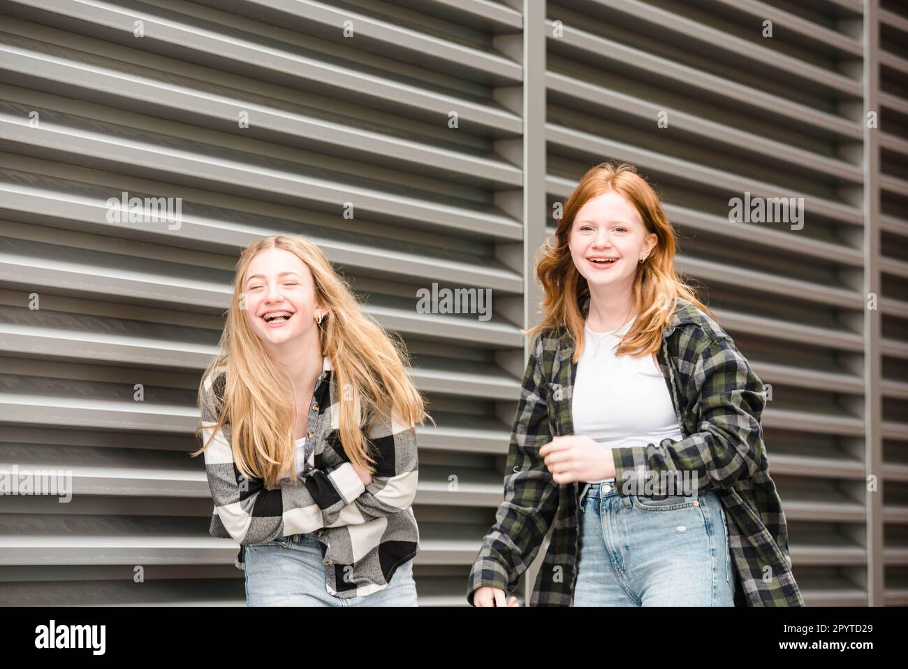 Two laughing teen girls walking together Stock Photo - Alamy
