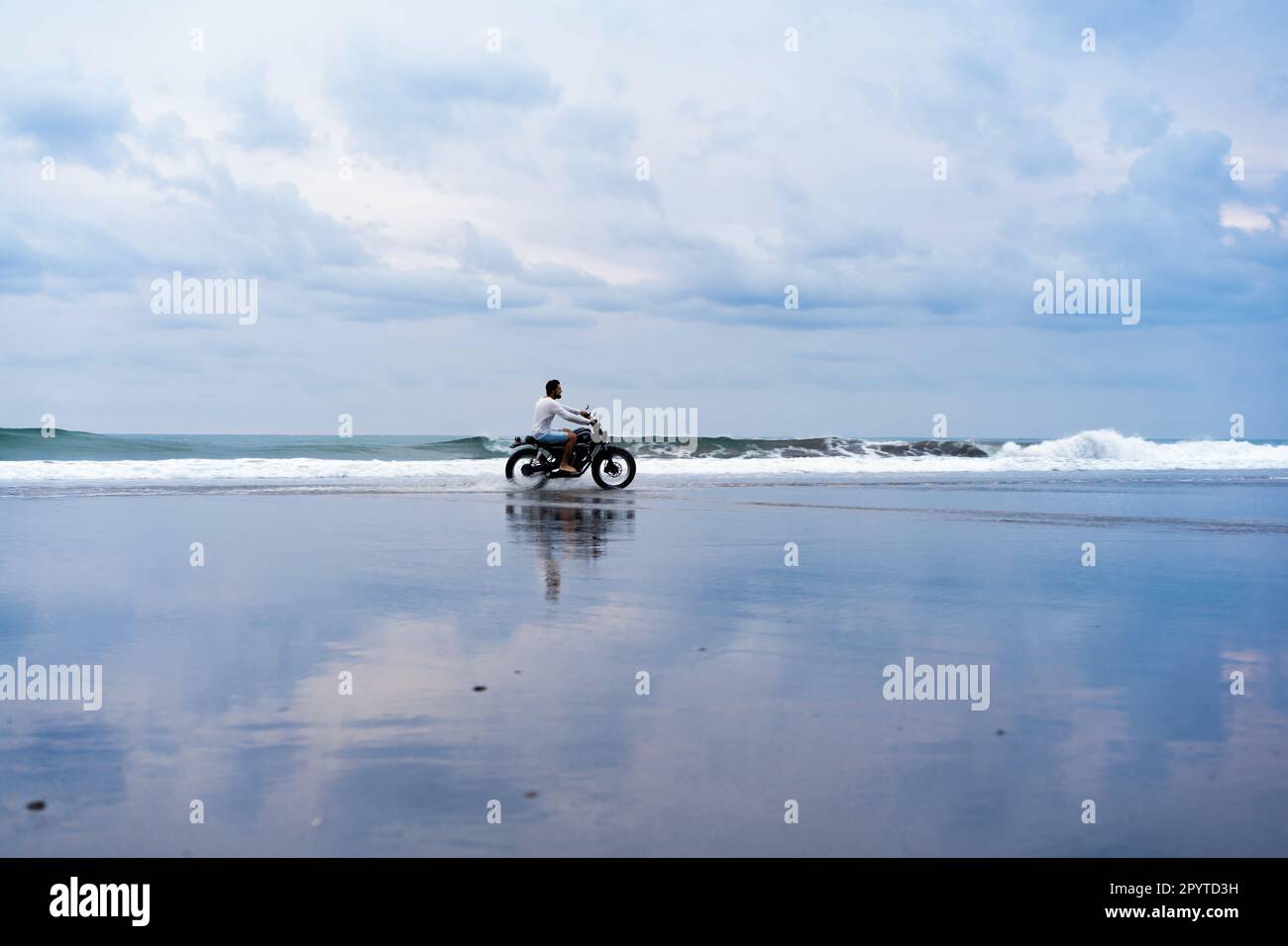 Man travels on a motorcycle in the ocean beach Stock Photo - Alamy