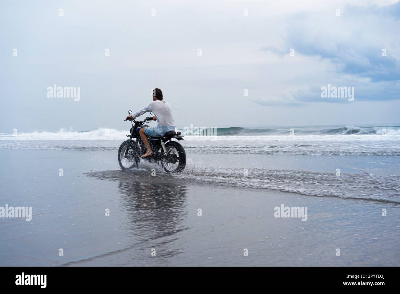 Man travels on a motorcycle in the ocean beach Stock Photo - Alamy