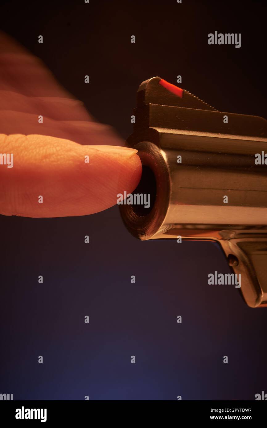Finger blocking the barrel and the firing of a pistol Stock Photo - Alamy