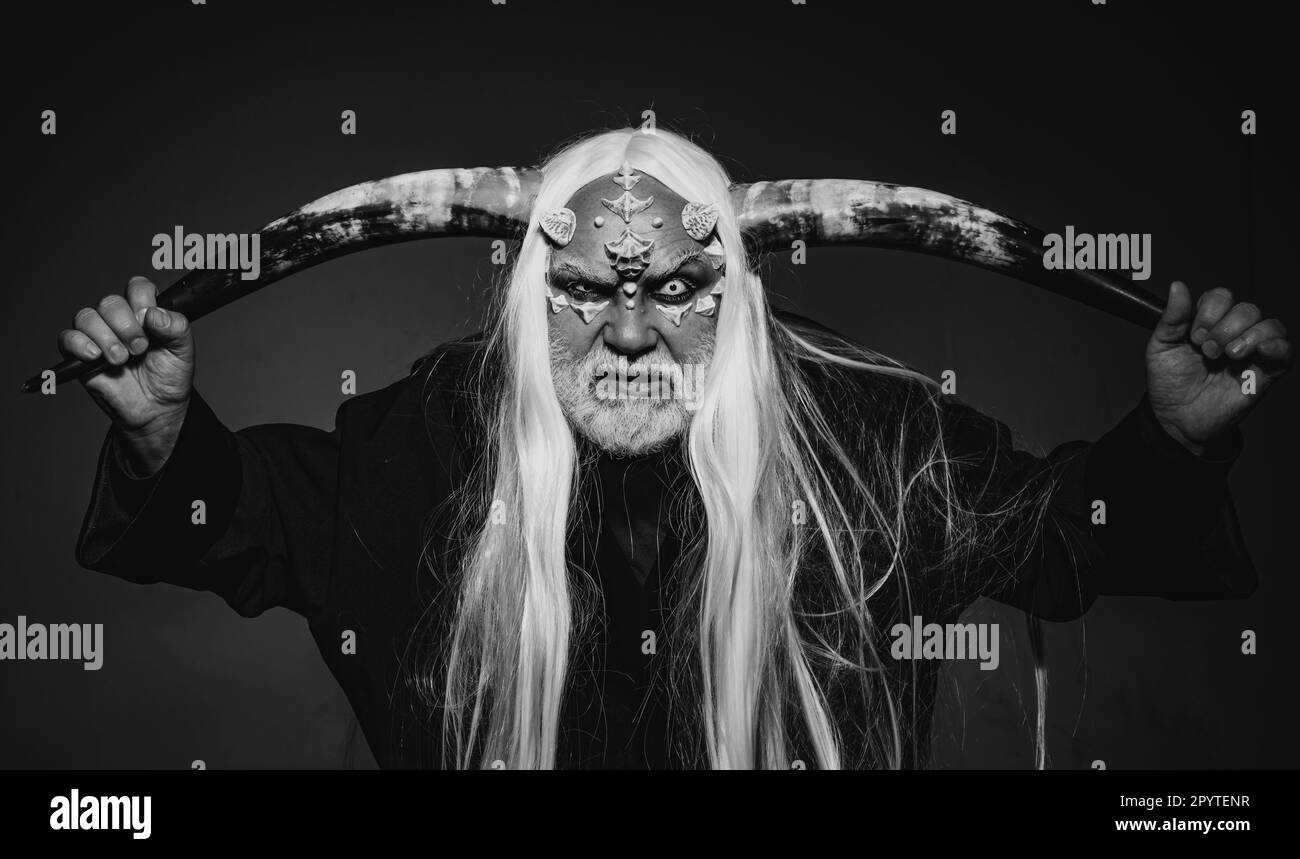 Viking with a horned head. Man wizard with fantastic make up on demon ...