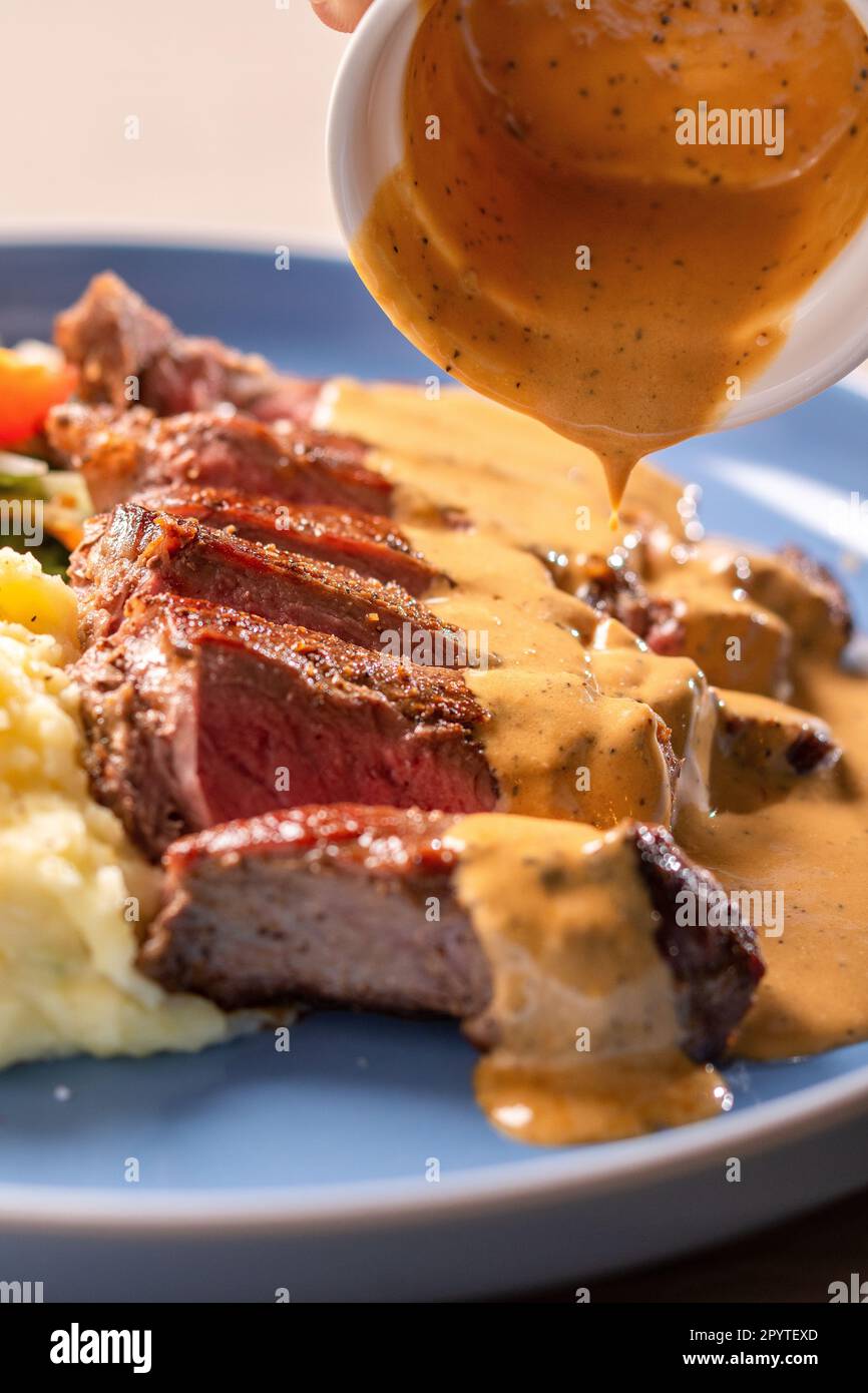 A chef pouring sauce over the meat Stock Photo - Alamy