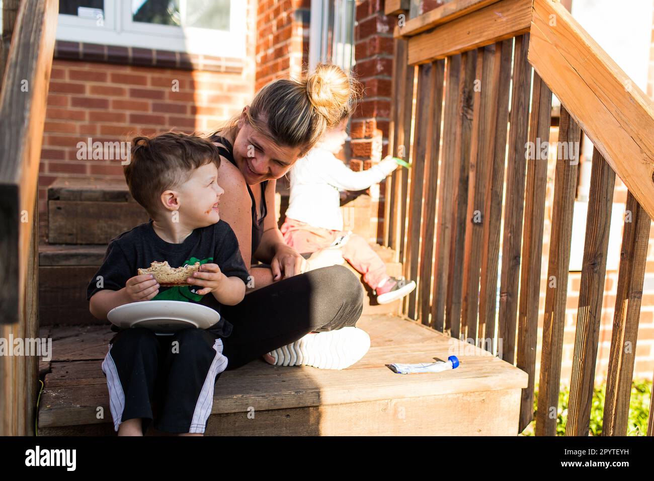 Mom and young children eating snacks outside Stock Photo - Alamy