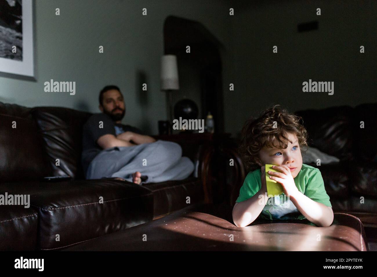 Young child and parent looking at something in living room Stock Photo ...