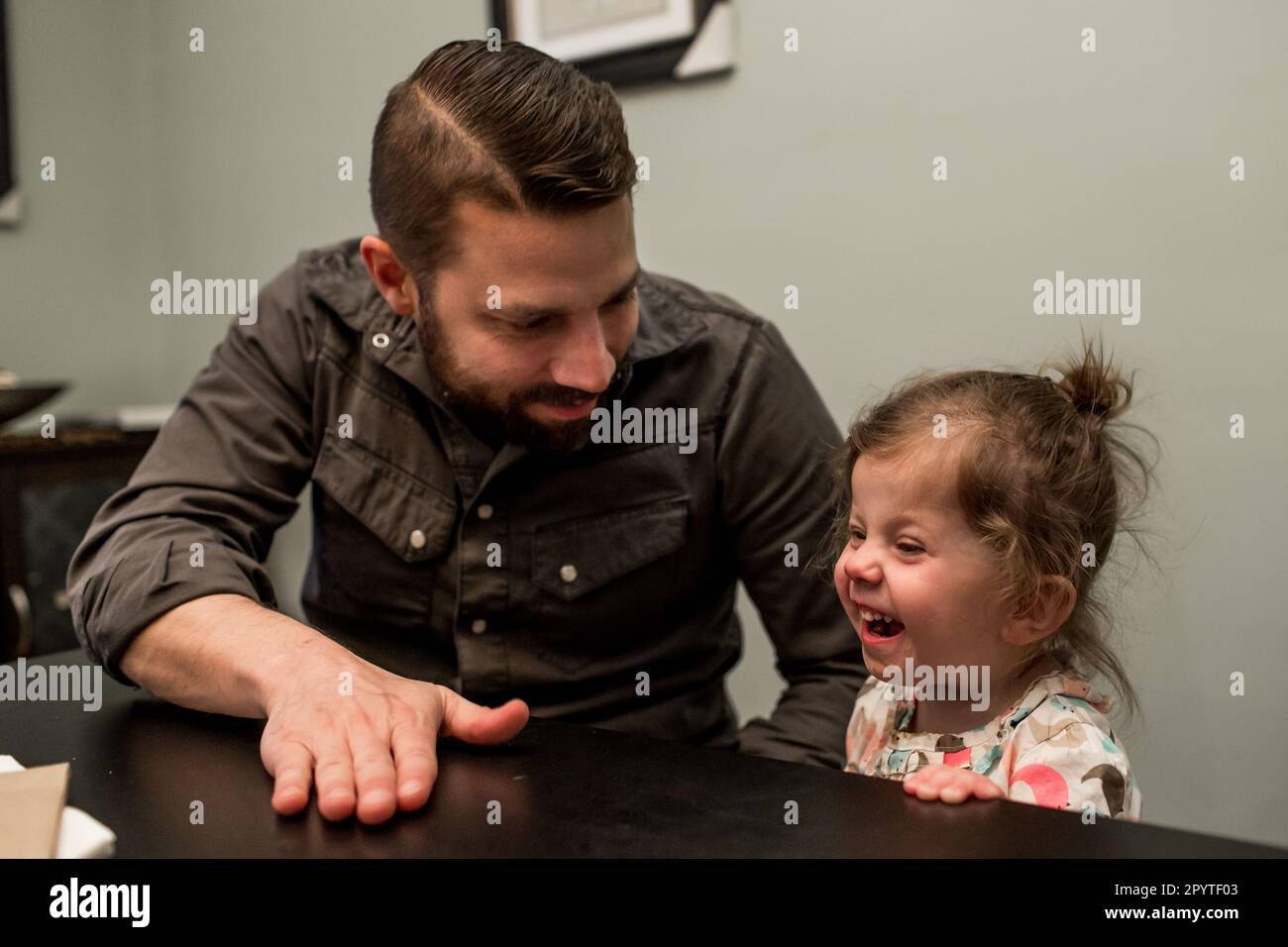 Dad and daughter being silly at dinner table Stock Photo - Alamy