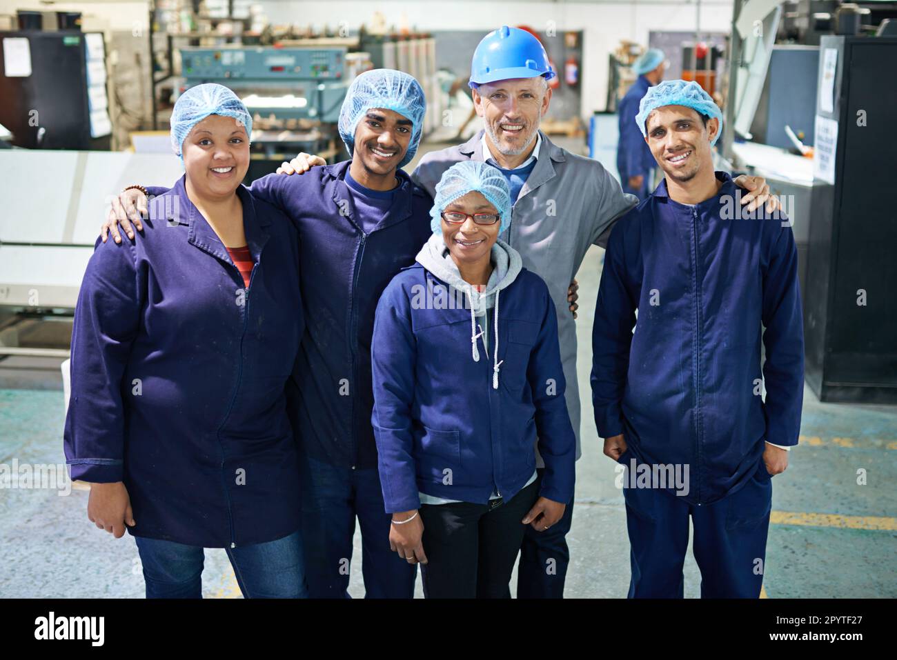 More than coworkers...Portrait of a manager standing arm in arm with ...