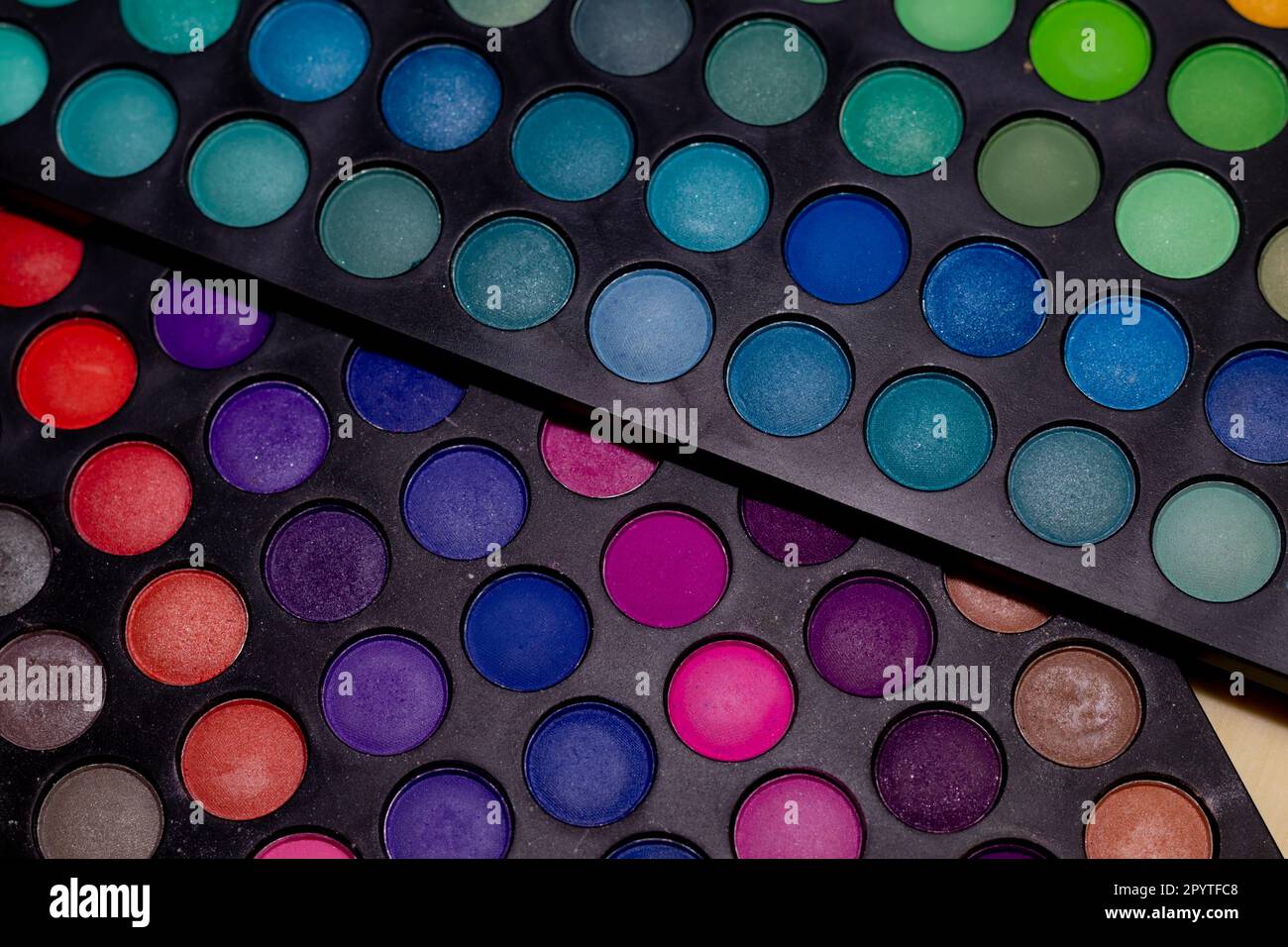 A closeup of a vibrant eyeshadow palette featuring a variety of ...