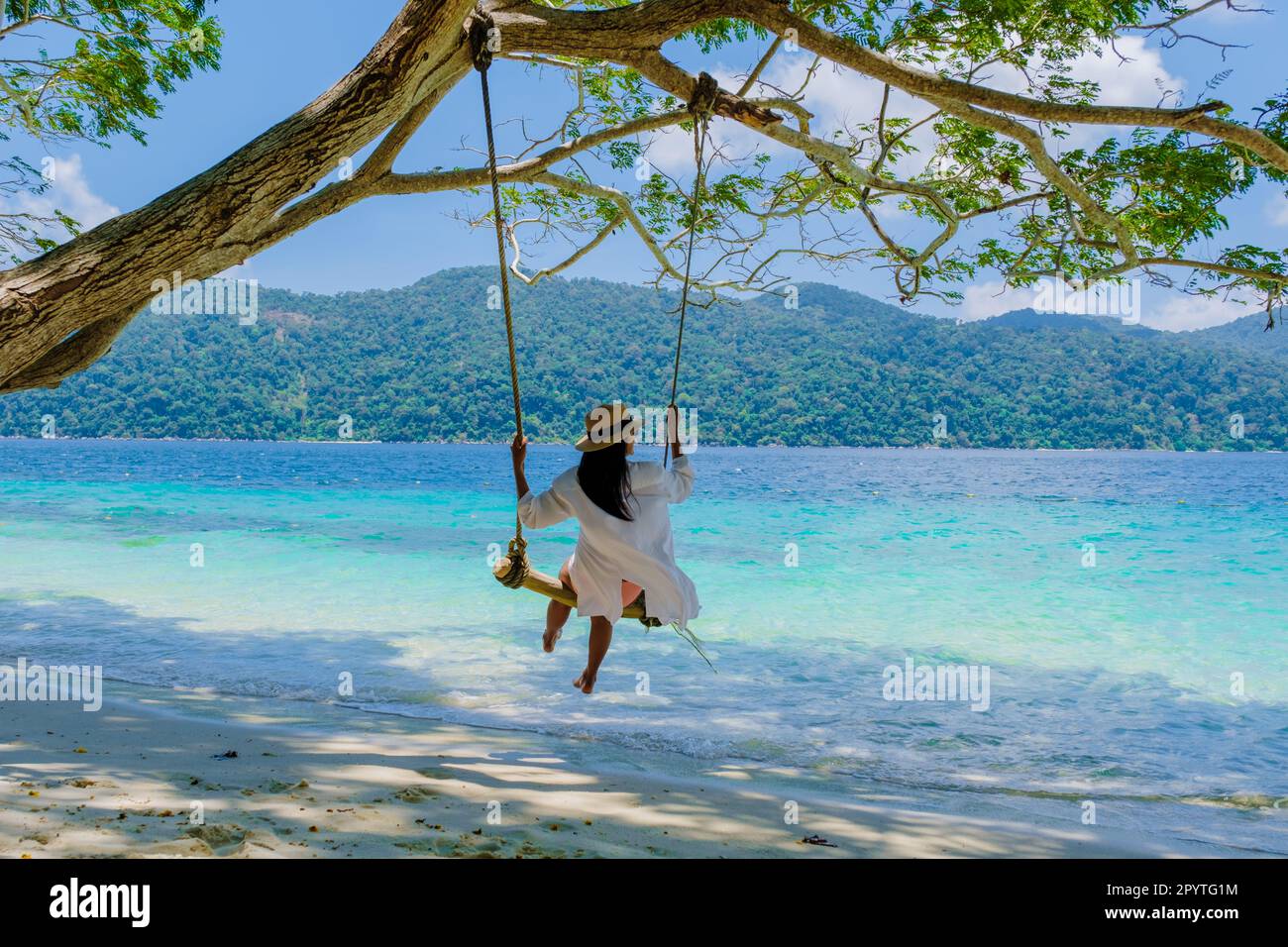 Women at a swing on the beach of Ko Ra Wi Island Southern Thailand ...