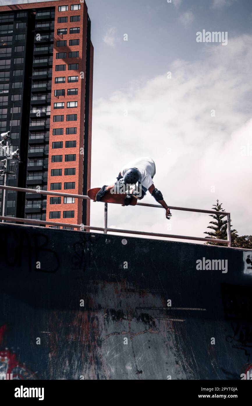 A young male skater performing a skateboarding trick as he ascends up ...