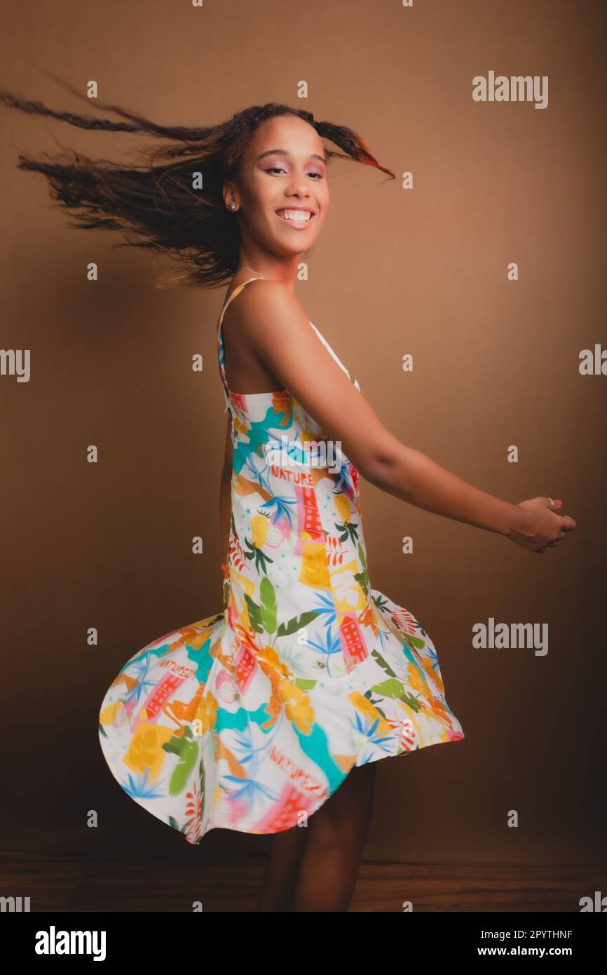 Teenage model, pretty, standing, moving hair against brown background ...