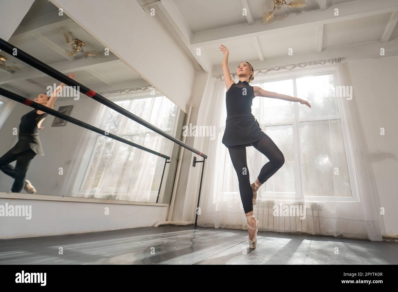 A beautiful Asian woman is dancing at the barre. Ballet dancer Stock ...