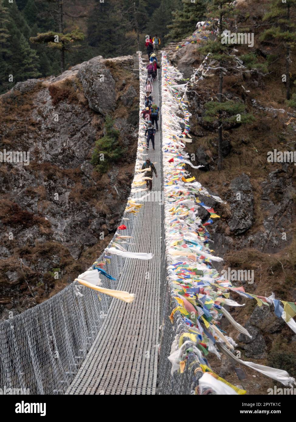 Buddhist prayer flags tied to a metallic hanging bridge called "Hillary ...