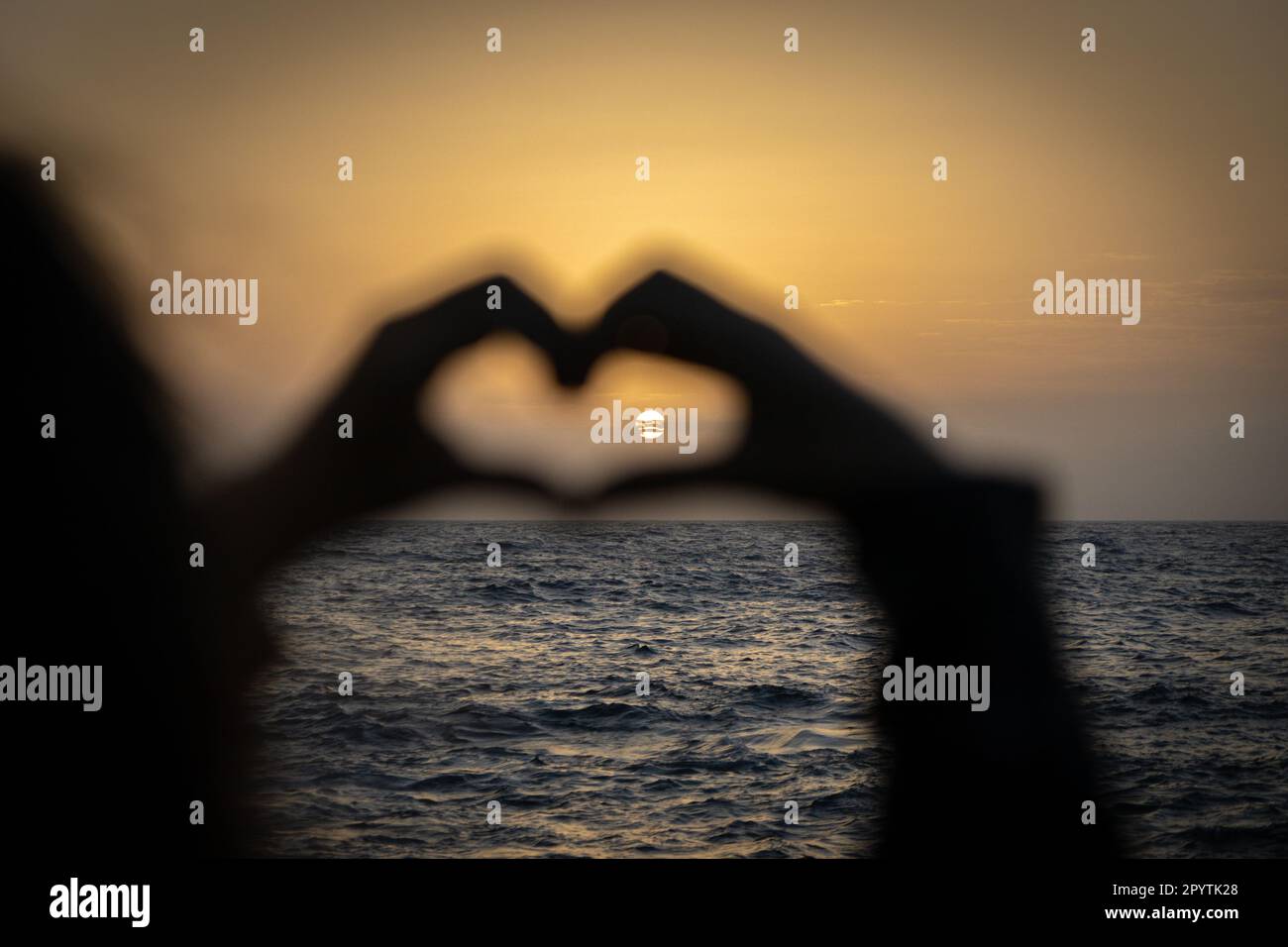 Female hands heart shape on nature bokeh sea sunset, tropical sunset ...